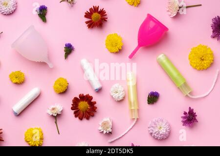 Menstrual cup and tampons on floral pattern background Stock Photo - Alamy