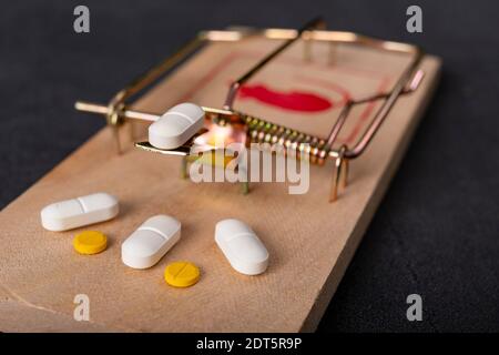 Medical tablets placed in a mousetrap. A trap for people in the form of ...