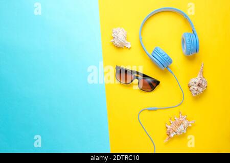 Beach music. Headphones, sunglasses, shells on yellow background. Top ...