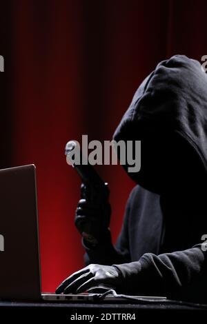 International hacker in black pullover and black mask trying to hack ...
