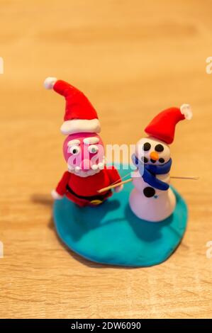 Christmas figures of Santa Claus and children playing in the snowy ...