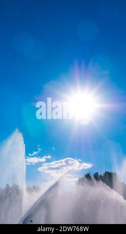 Fountain splashing in still lake Stock Photo - Alamy