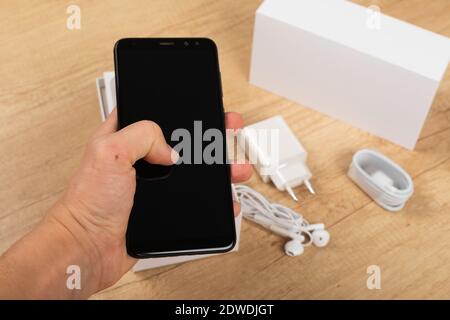 Picture of new smartphone unboxing in front of wooden background Stock ...