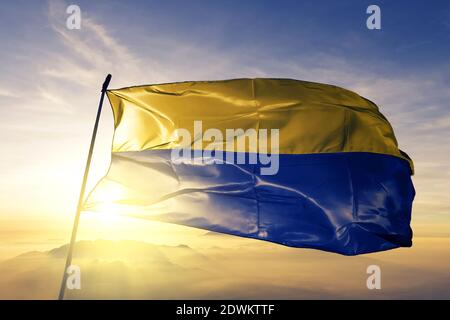 official flag of Perlis Malaysia at cloudy sky background on sunset ...