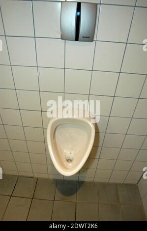 an urinal in a restroom, body hygiene and basic needs urinal in a mens ...