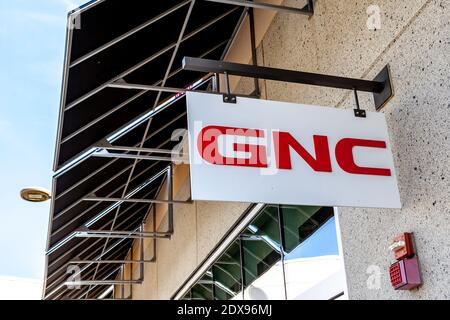 GNC Live Well sign on exterior of commercial building with blue tile ...