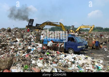 Scavengers are active in piles of rubbish in the landfill (TPA) of ...