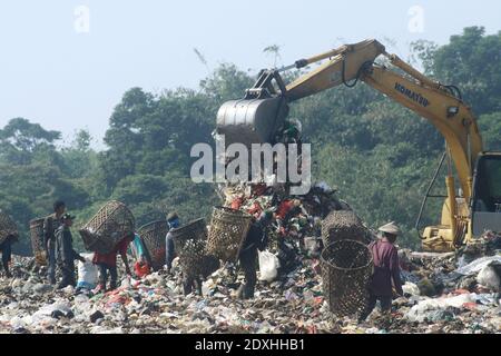 Scavengers are active in piles of rubbish in the landfill (TPA) of ...