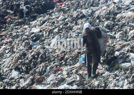 Scavengers are active in piles of rubbish in the landfill (TPA) of ...