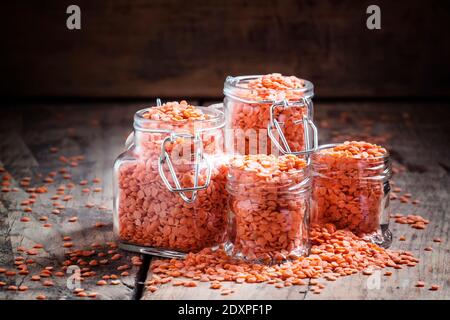 Useful red lentils in glass jars for storage on old wooden background ...