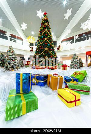 Many gift boxes under Christmas tree indoors, closeup. Space for text ...