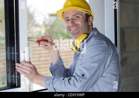 happy man drilling window frame Stock Photo - Alamy