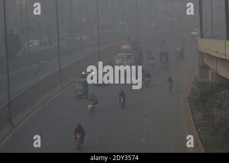 Pakistani Commuters make their way amid dense fog on a cold winter ...