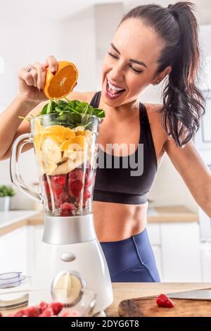 A girl squeezes fresh orange juice in a juicer in a supermarket Stock ...