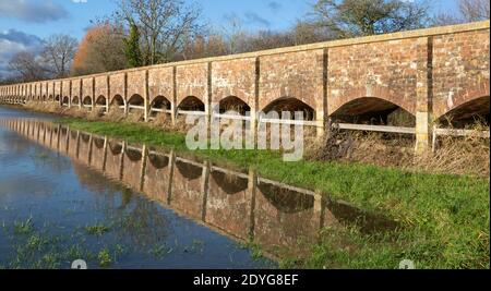 Arches of Maud Heath's causeway reflected by flood water of River Avon ...