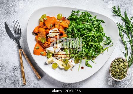 Salad with arugula, baked pumpkin and brie cheese. White background ...