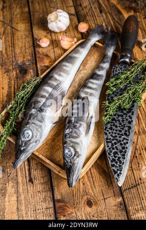 Raw mackerel icefish in a wooden tray. Wooden background. Top view ...