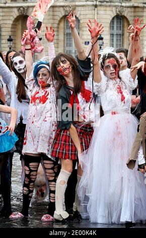 People dressed up as zombies take part in a Zombie Walk at the center ...