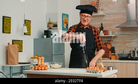 Experienced baker spreading flour in home kitchen for food preparation ...