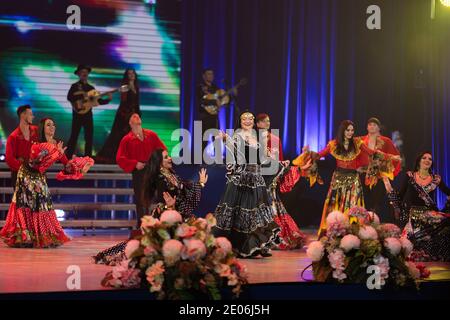 A team of musicians and singers perform on stage in front of the ...