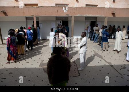 Senegalese stand in line to cast their vote at the polling station ...