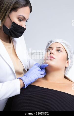 Cosmetologist making the rejuvenating facial injections procedure for ...