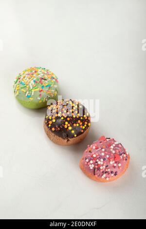Colorful sweet small doughnuts on a white background Stock Photo - Alamy