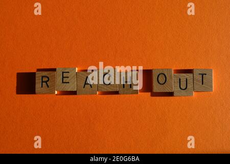 Reach Out, words in wooden alphabet letters isolated on blue background ...