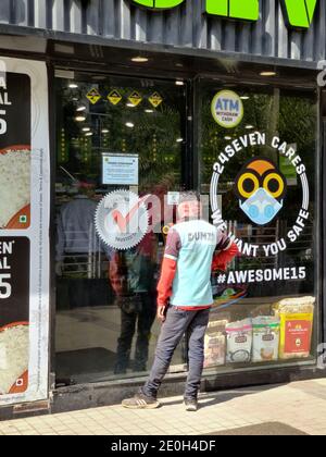 Hyperlocal delivery guy in blue Dunzo uniform standing outside 24Seven ...
