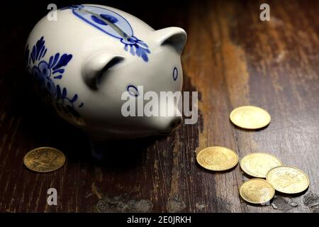 Blue old piggy bank with coins on a wooden table Stock Photo - Alamy