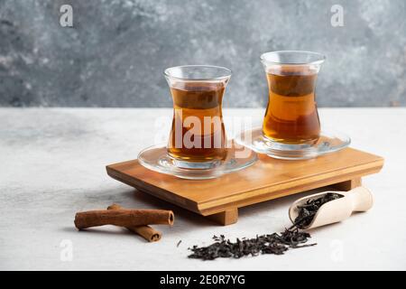 Two glass cups of tea and with cinnamon sticks and wooden dipper Stock ...