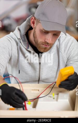 male electrician using multimeter on fusebox Stock Photo - Alamy