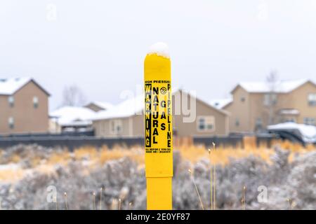 Gas pipeline marker post, warning of gas pipes below ground, on grass ...