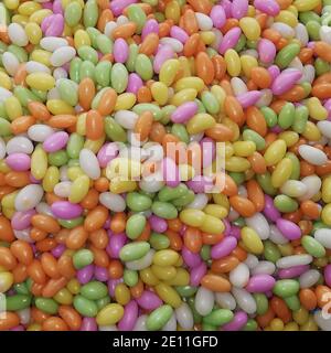 Multi colored sweet fennel sugar candy in white spoons against white ...