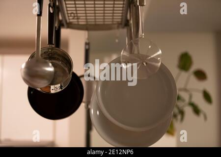 Stainless steel pans on rack above island unit in a country kitchen ...