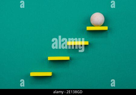 Leadership ball climbing the steps to the top Stock Photo - Alamy