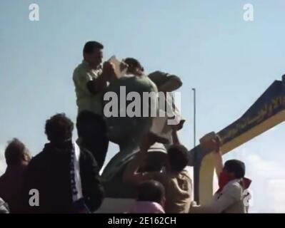 A statue of late Syrian President Hafez Assad lies destroyed in Dayr ...