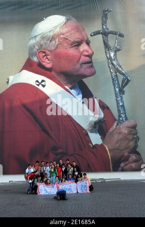 People walk past a giant placard showing picture of late pope John Paul ...