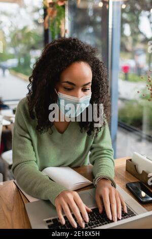 Woman in mask studying in computer class Stock Photo - Alamy