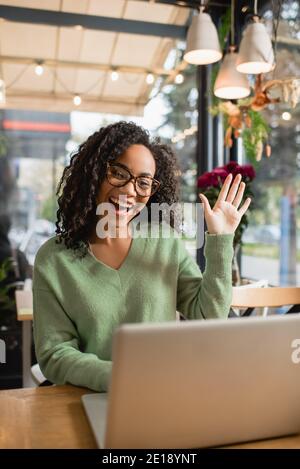 amazed and happy woman waving hand during video chat on laptop Stock ...
