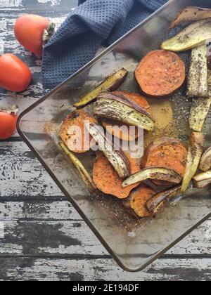 From above of raw sweet potatoes and fresh red oca in carton box placed ...