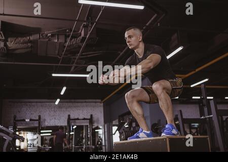 Low angle shot of shirtless male bodybuilder on dark background Stock ...
