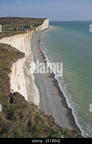A view of the cliff fall of birling gap beach with people sitting on it ...