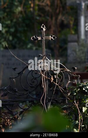 A closeup of an ancient metal Cemetery cross against a stone wall Stock ...