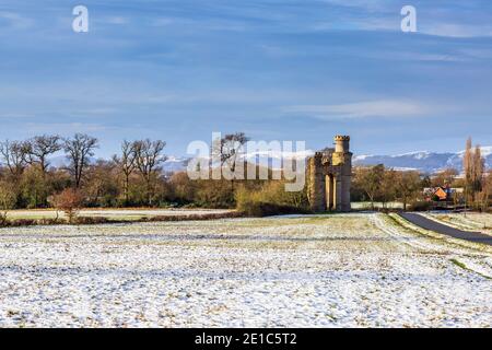 Snow covered Dunstall Common and Castle with the Malvern hills in the ...