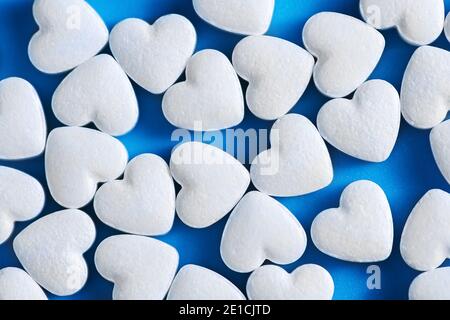 heart-shaped tablets on blue background. medicine, cardiology, health ...