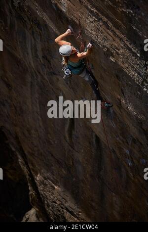 High angle view shot of an adventurous man rock climbing up a cliff ...