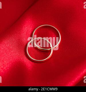 Golden wedding rings, in the background the bride's bouquet of multi ...