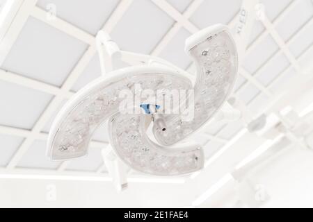 Hospital operating room, with overhead surgical lights, and may have ...