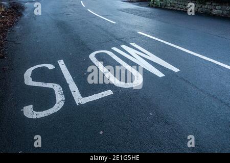 Slow road marking word on a road with a bend taken from above Stock ...